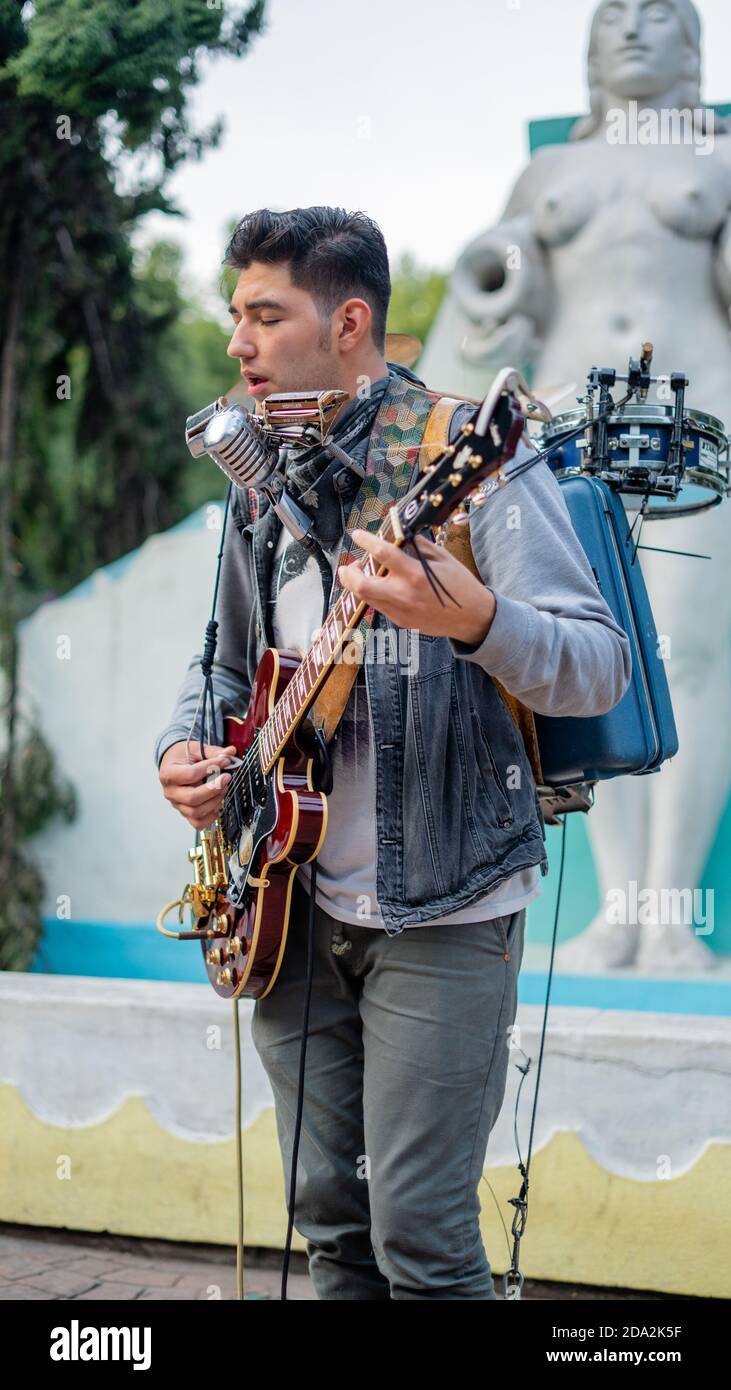 Man Playing Several Instruments at Once Performs in Front of a Fountain ...