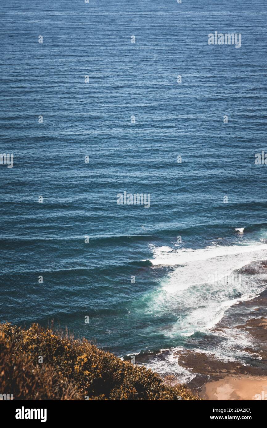 High angle shot of the ocean as seen from a grassy cliff in the coast ...