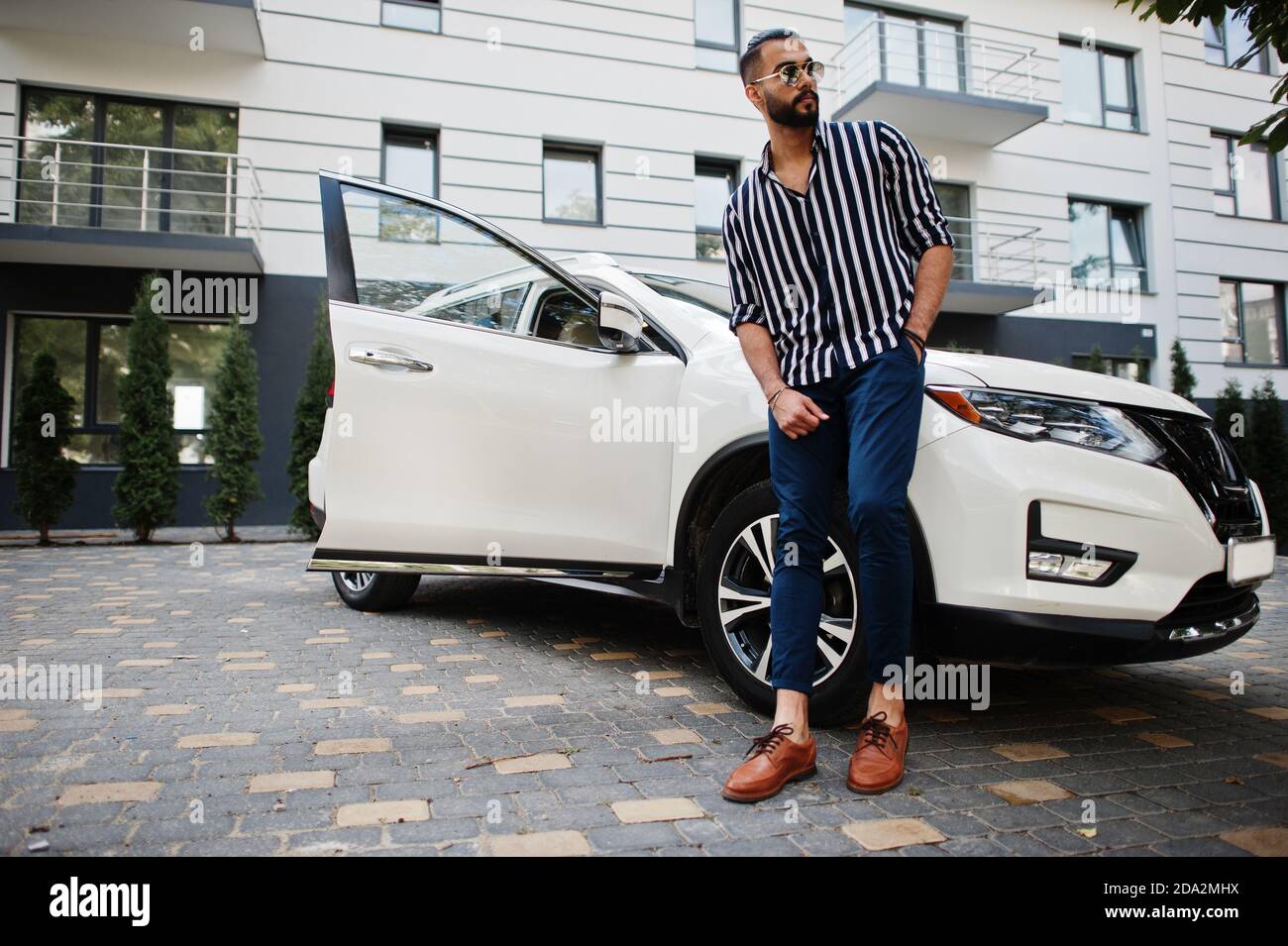 Successful arab man wear in striped shirt and sunglasses pose near his ...