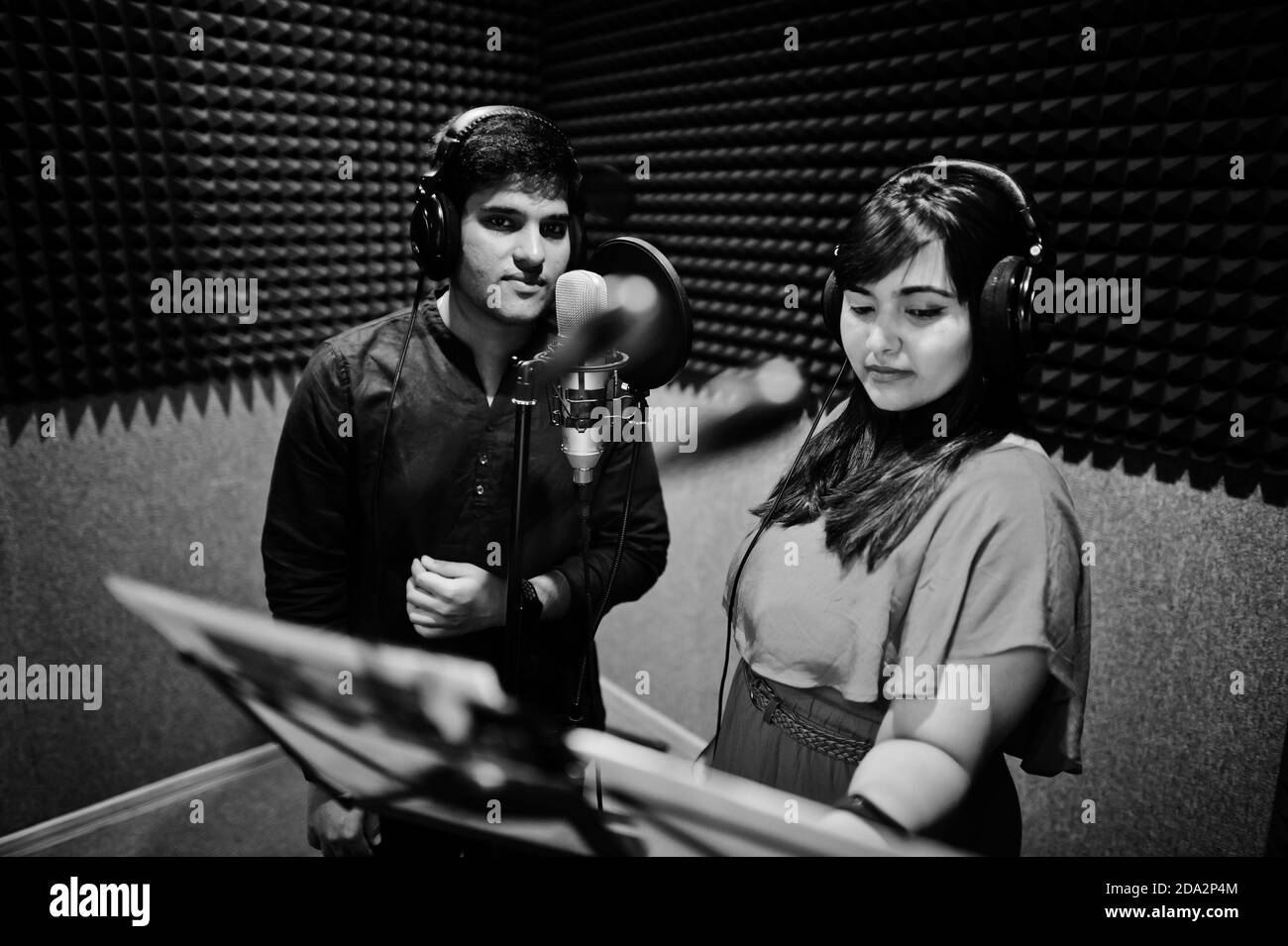 Young asian duet singers with microphone recording song in record music ...