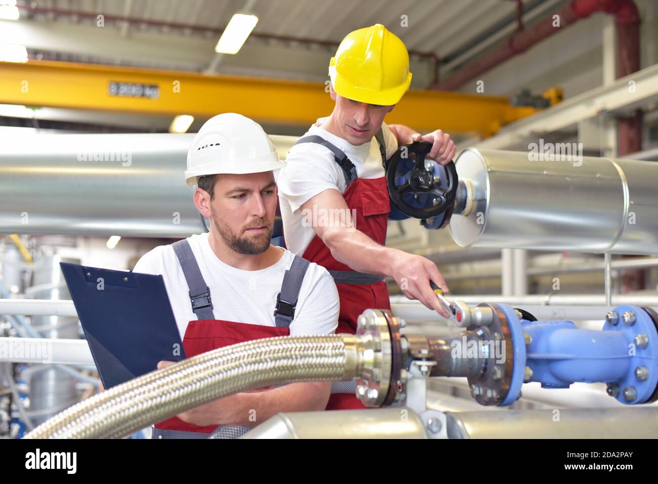 Mechanics repair a machine in a modern industrial plant - profession ...