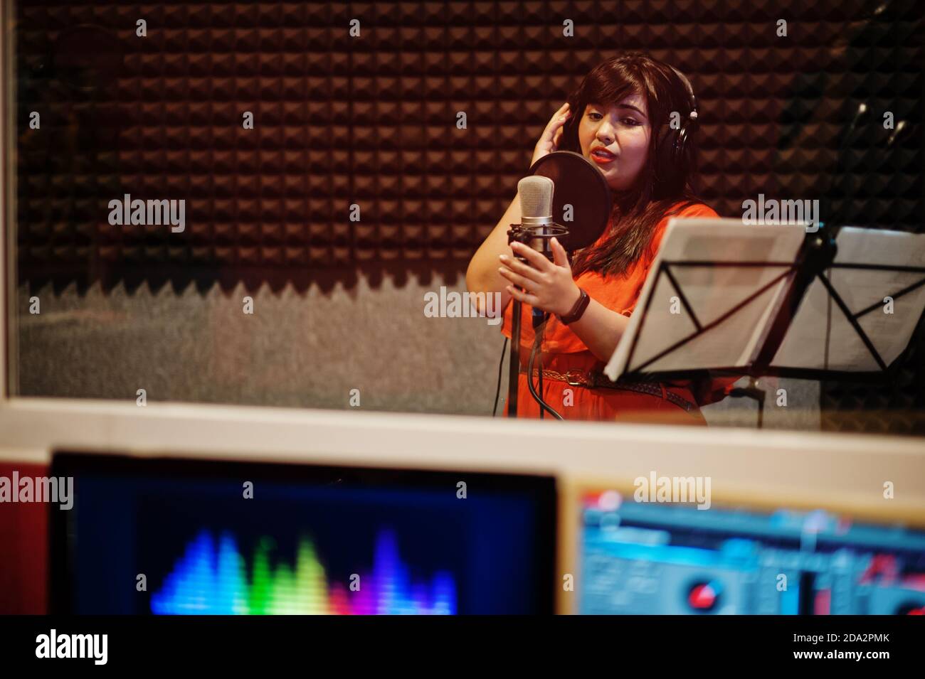 Young asian singer with microphone recording song in record music ...