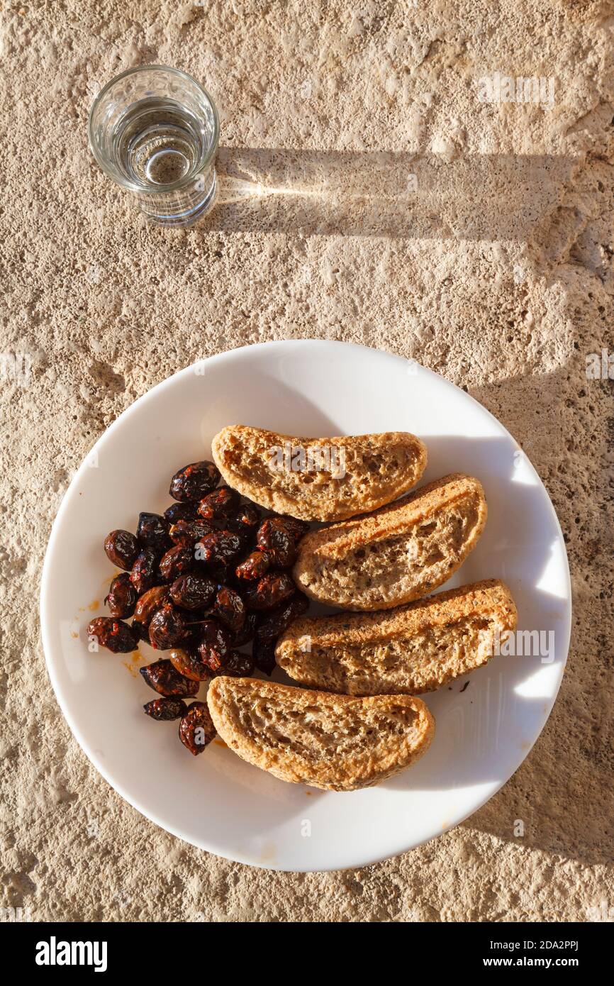 Cretan rusks, olives and tsikoudia (raki), a delicious snack meal as ...