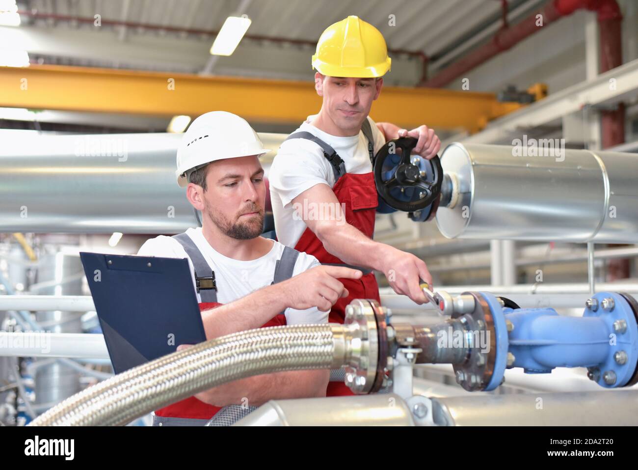 Mechanics repair a machine in a modern industrial plant - profession ...