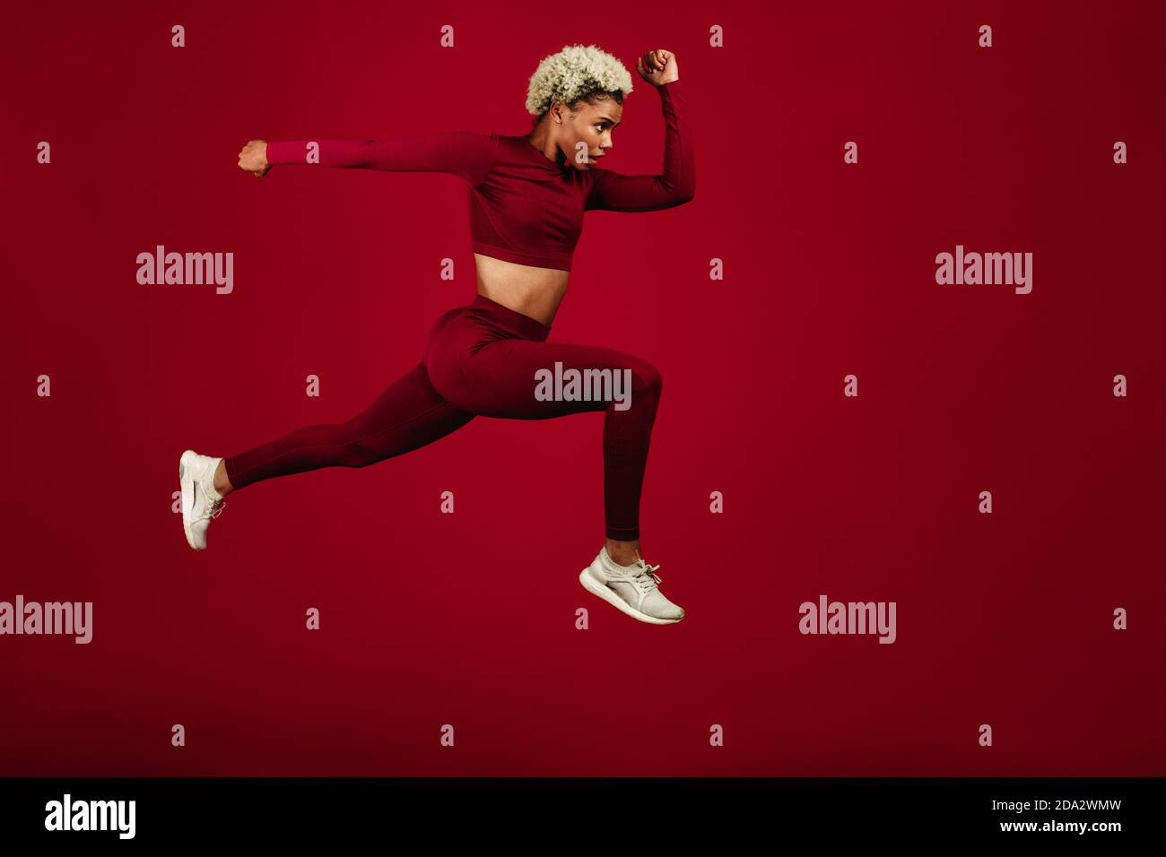 African american runner taking long strides during a sprint. Side view ...