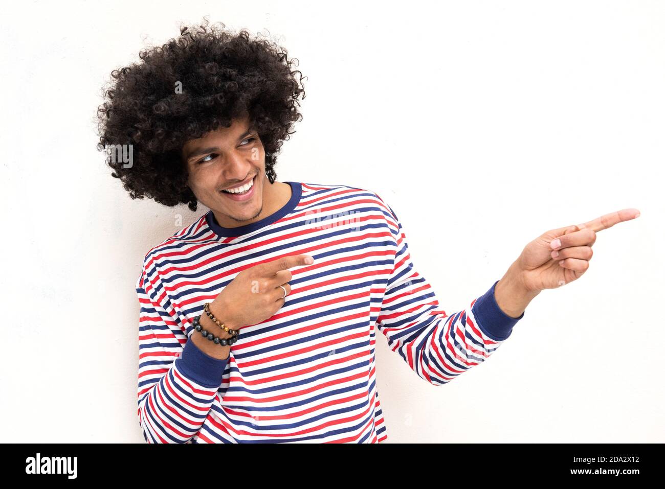 Portrait smiling young arabic man with afro hair pointing fingers to ...