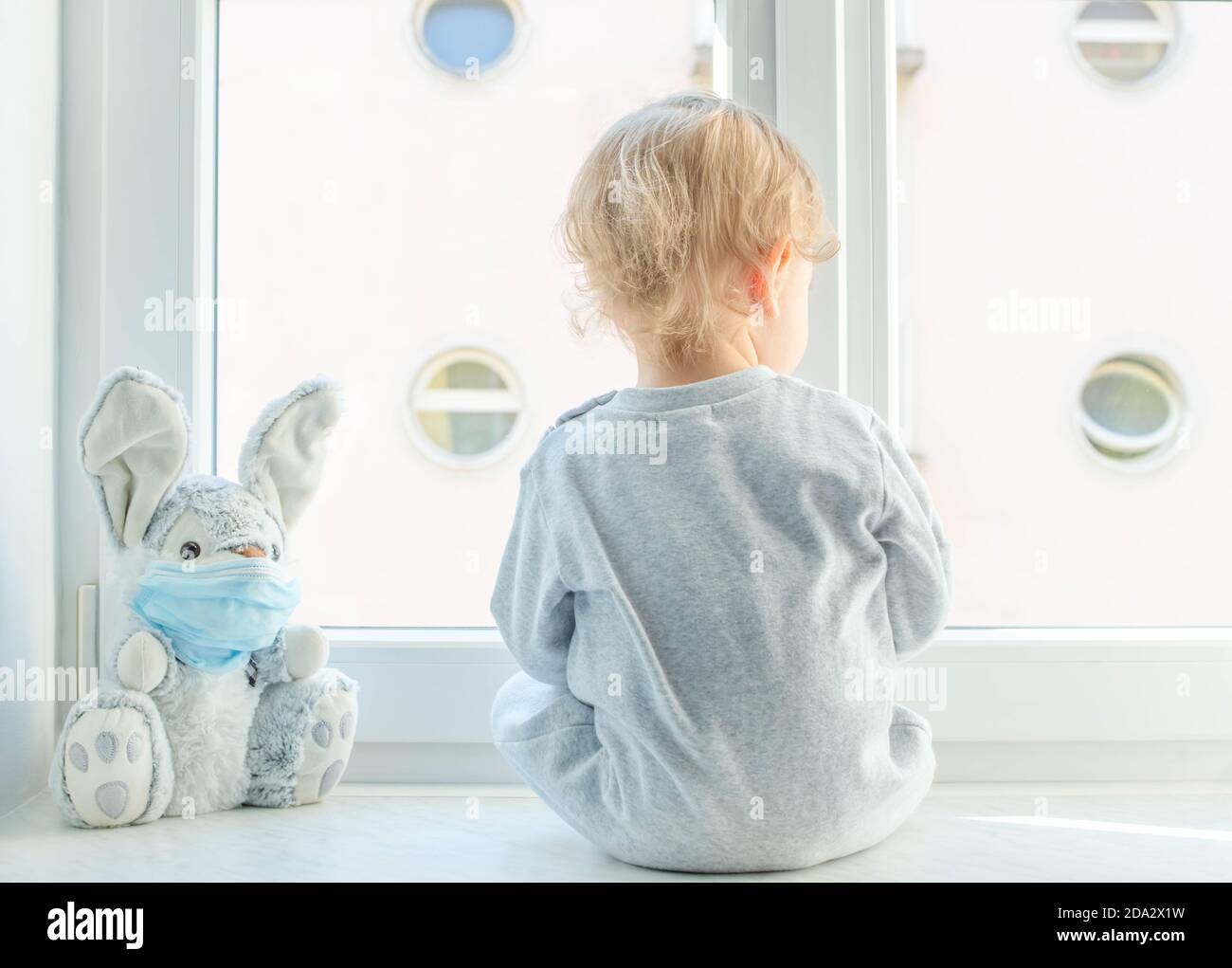 Easter 2021 concept with child in home quarantine playing at the window ...