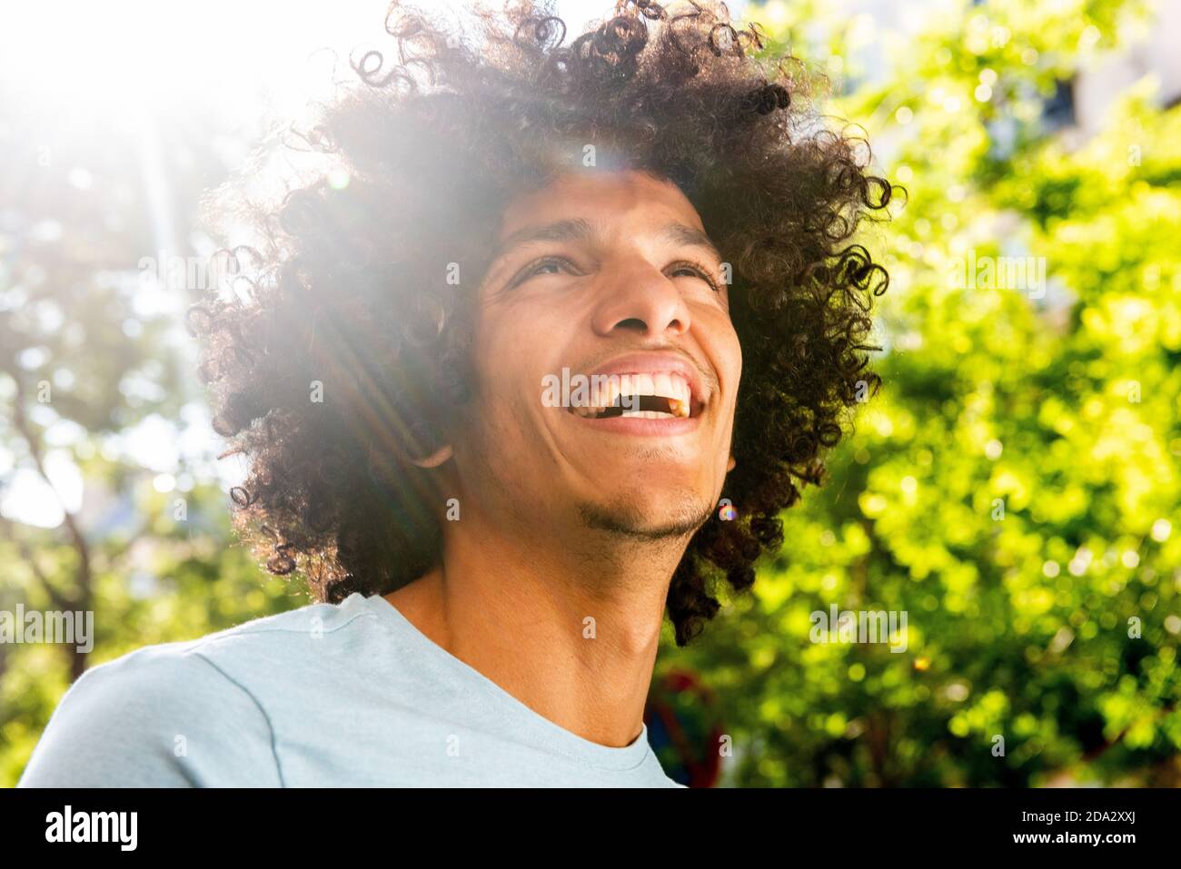 Close up portrait smiling handsome young arabic man with afro hair ...