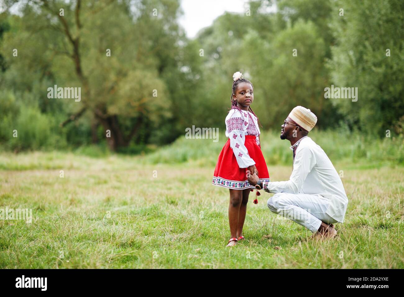 African father with daughter in traditional clothes at park Stock Photo ...
