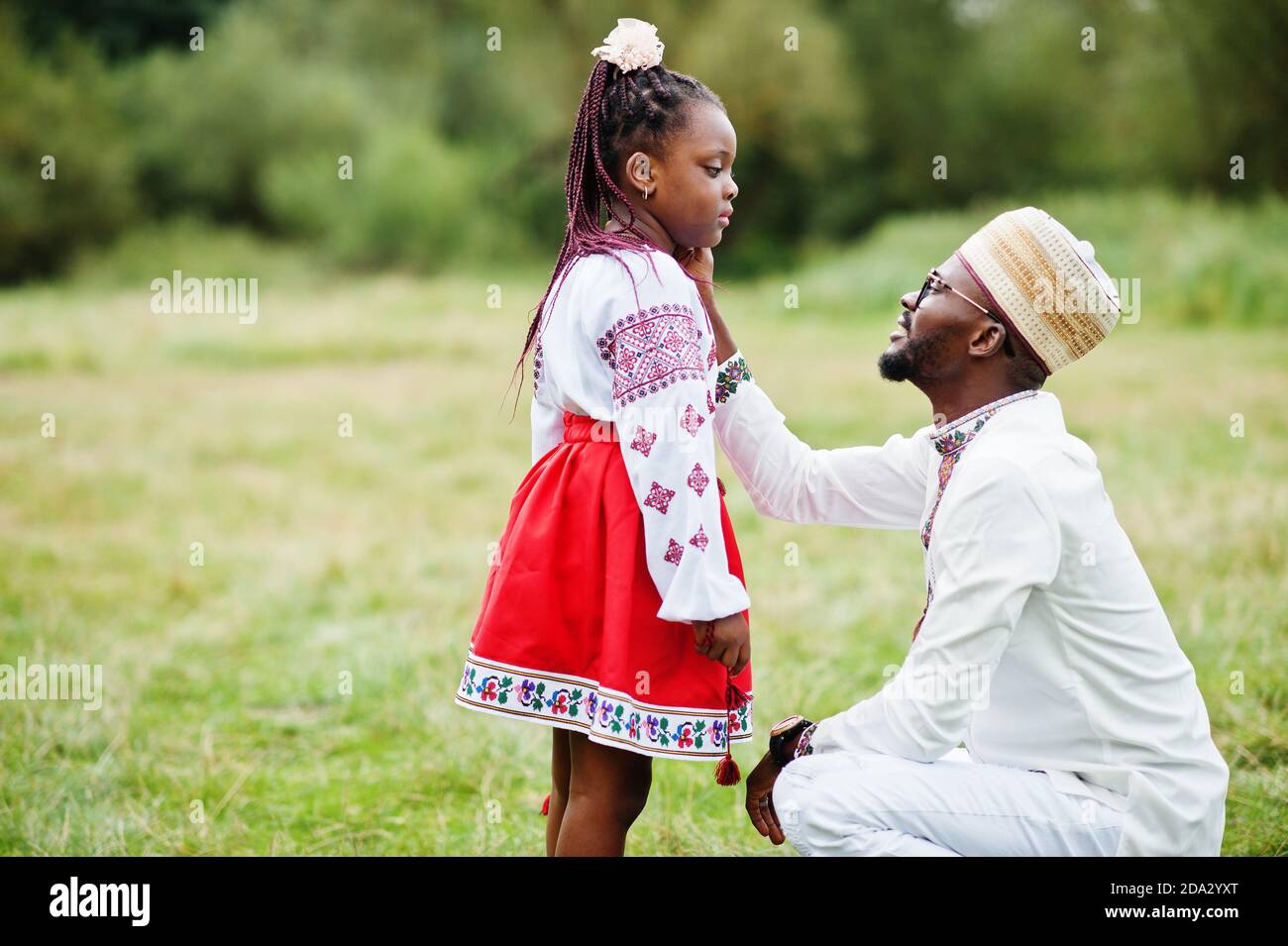 African father with daughter in traditional clothes at park Stock Photo ...