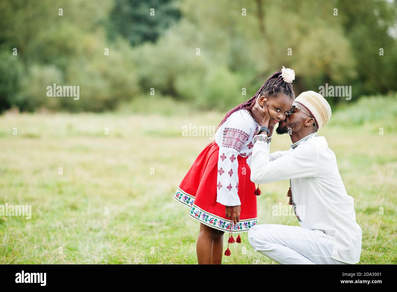 African father with daughter in traditional clothes at park Stock Photo ...