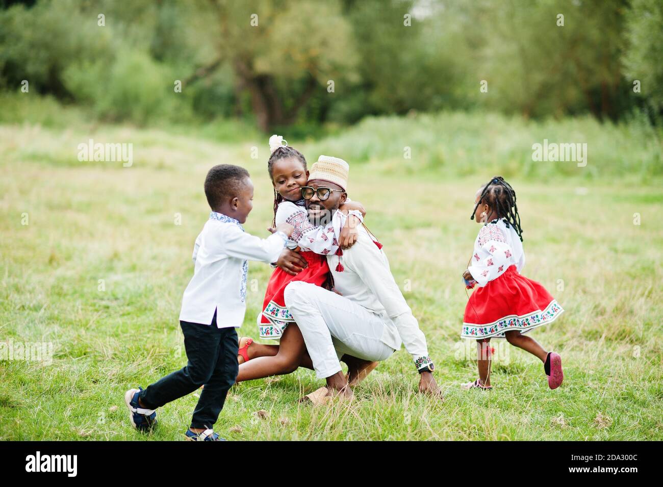 African father with kids in traditional clothes at park Stock Photo - Alamy