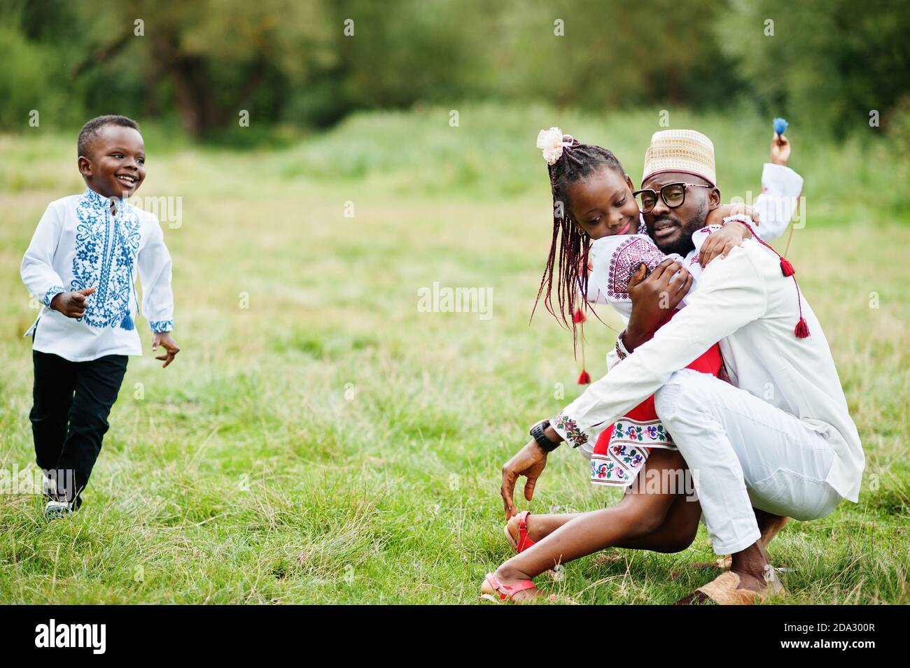 African father with kids in traditional clothes at park Stock Photo - Alamy