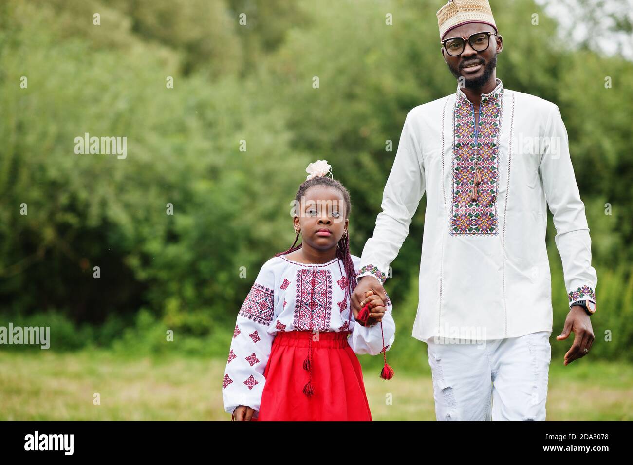 African father with daughter in traditional clothes at park Stock Photo ...