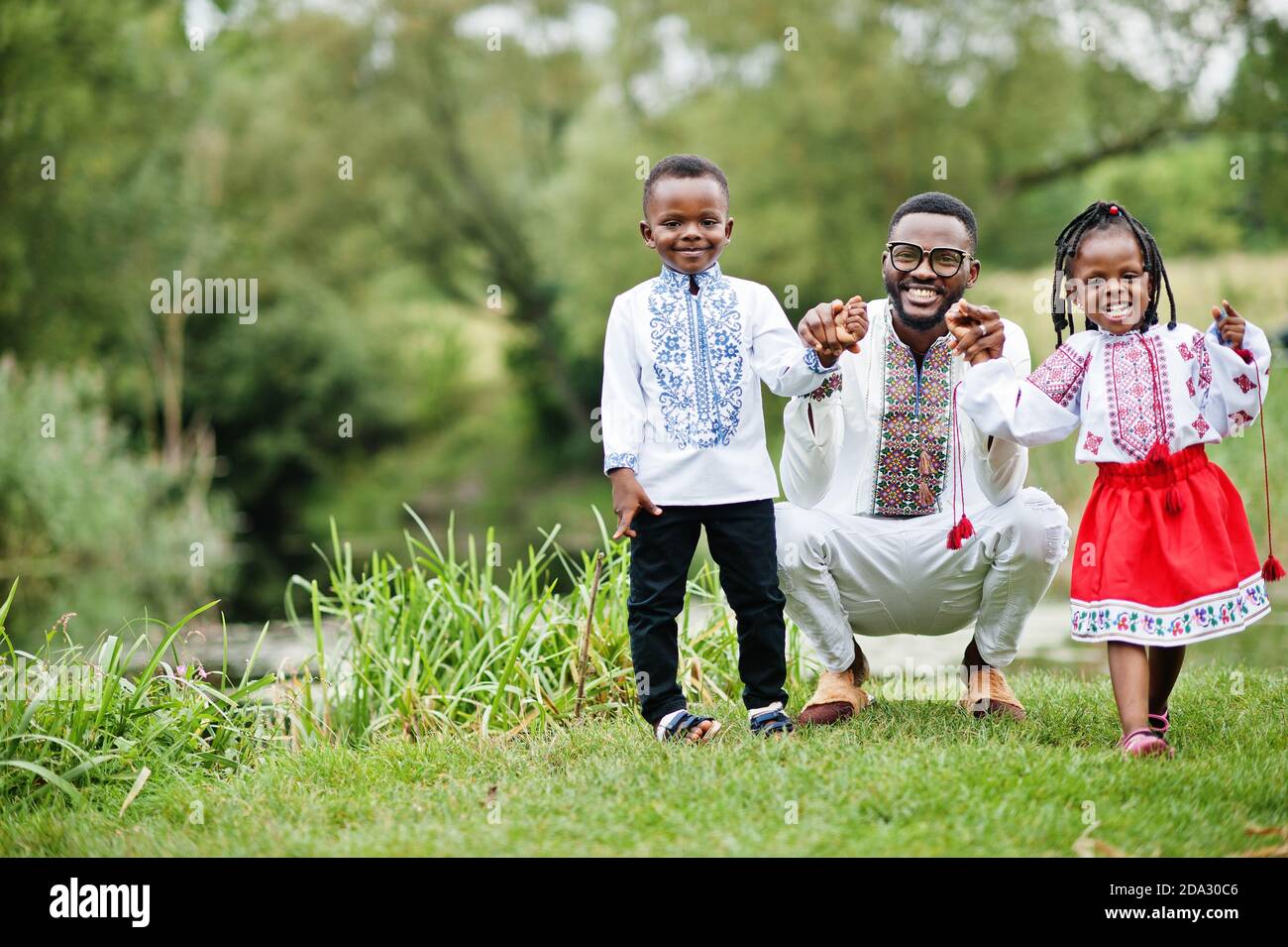 African father with kids in traditional clothes at park Stock Photo - Alamy