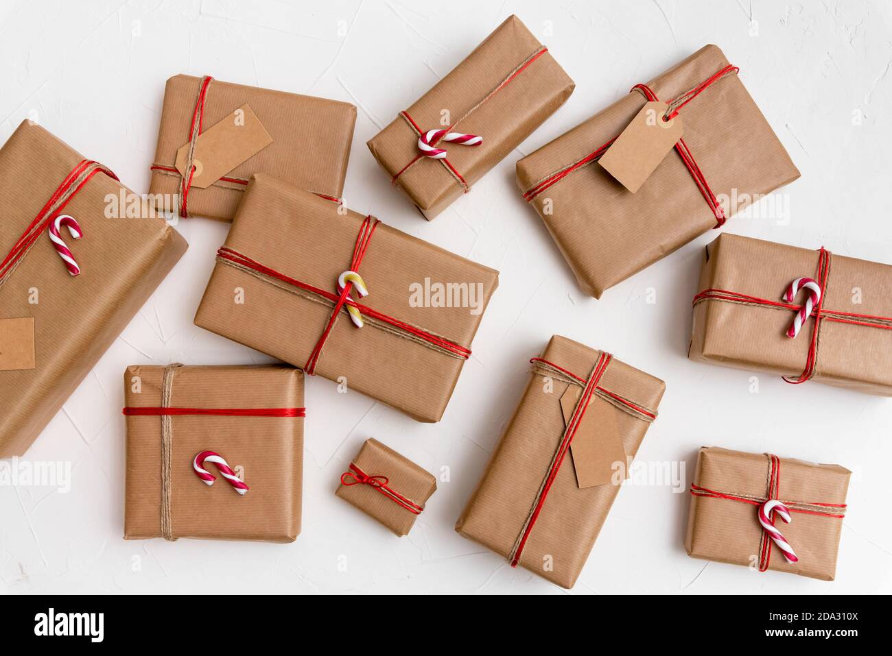 Christmas gift boxes wrapped in craft paper with red string and candy ...