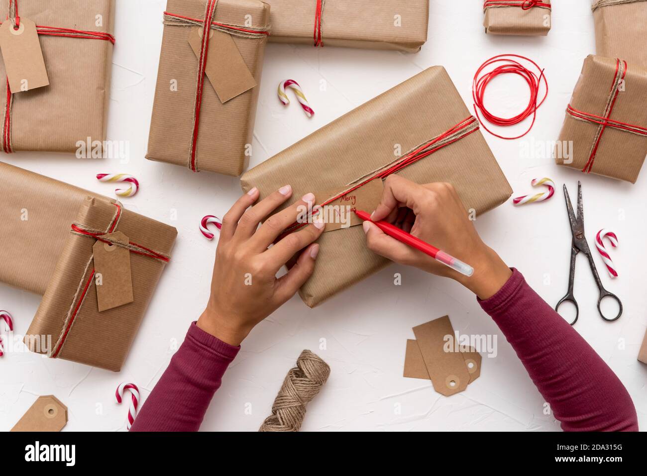Female's hands writing Christmas cards on gift boxes decorated with ...