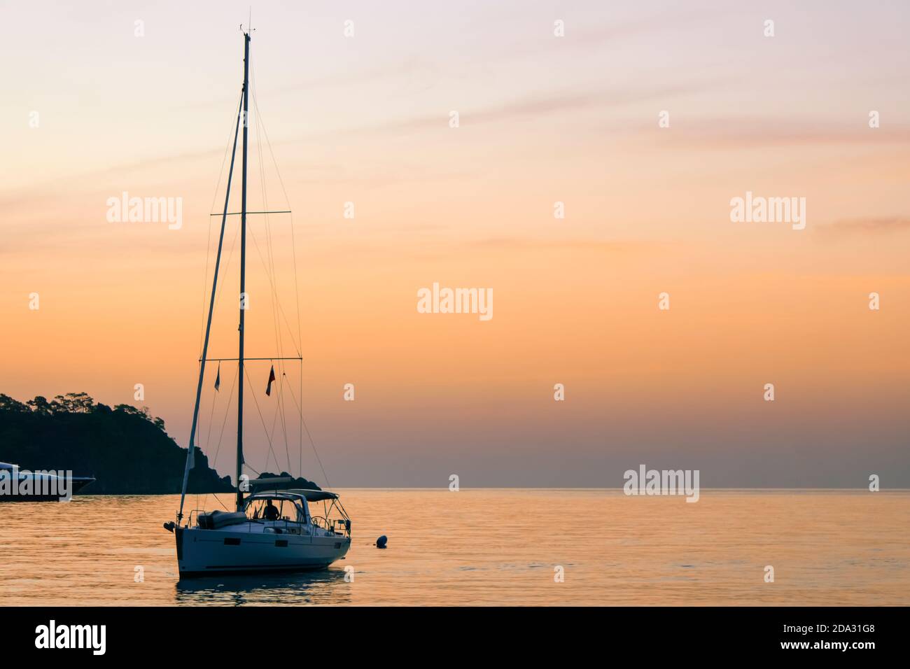 Yacht at sunset. A yacht in the sea bay against the backdrop of a ...