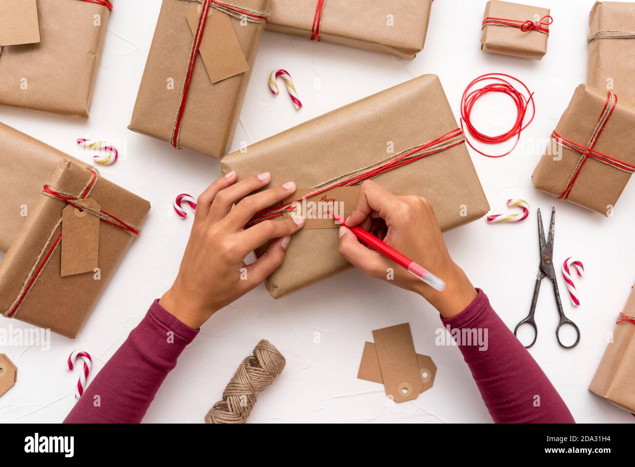 Female's hands writing Christmas cards on gift boxes decorated with ...