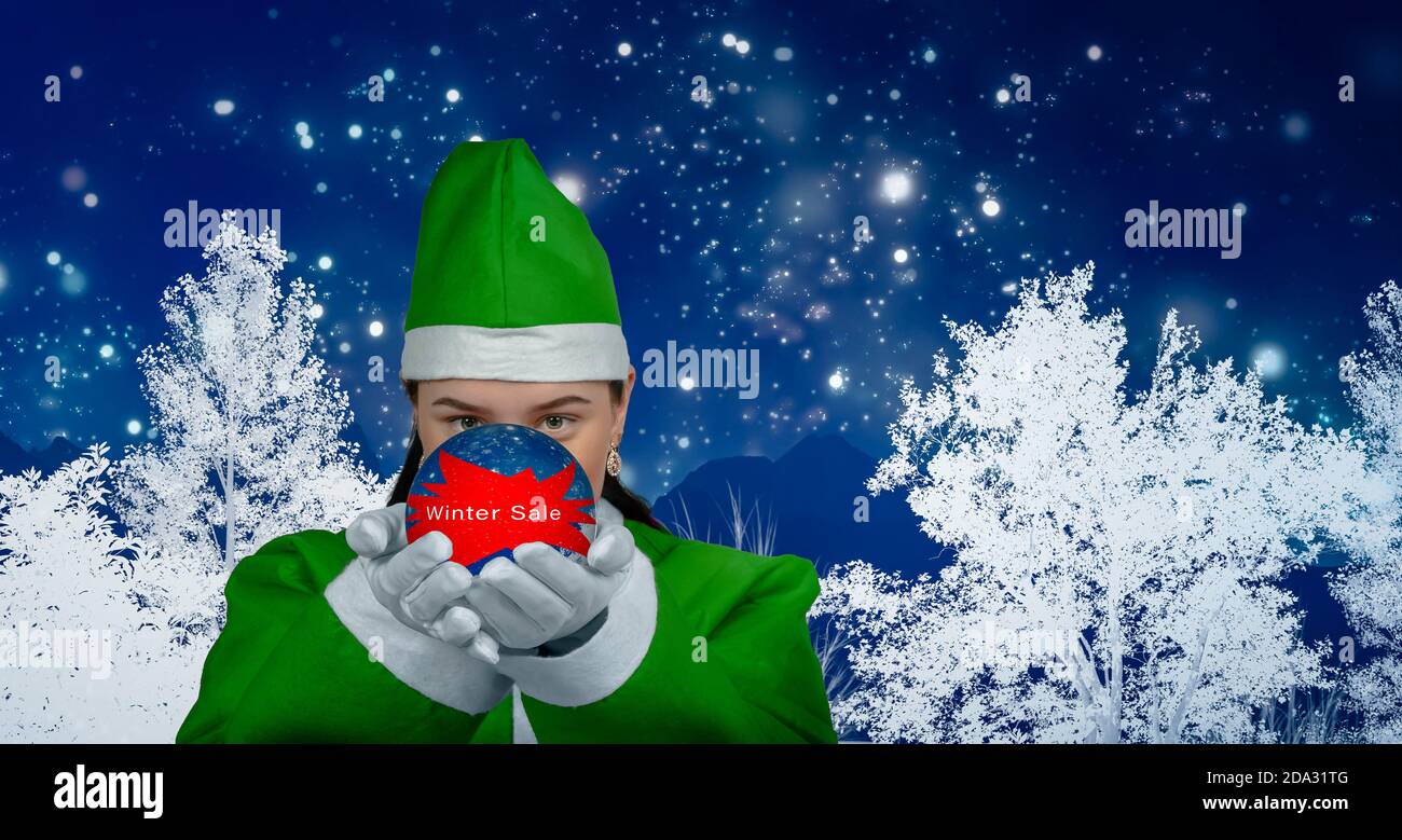 an elf advertises the winter sale with a glass ball in her hand Stock ...