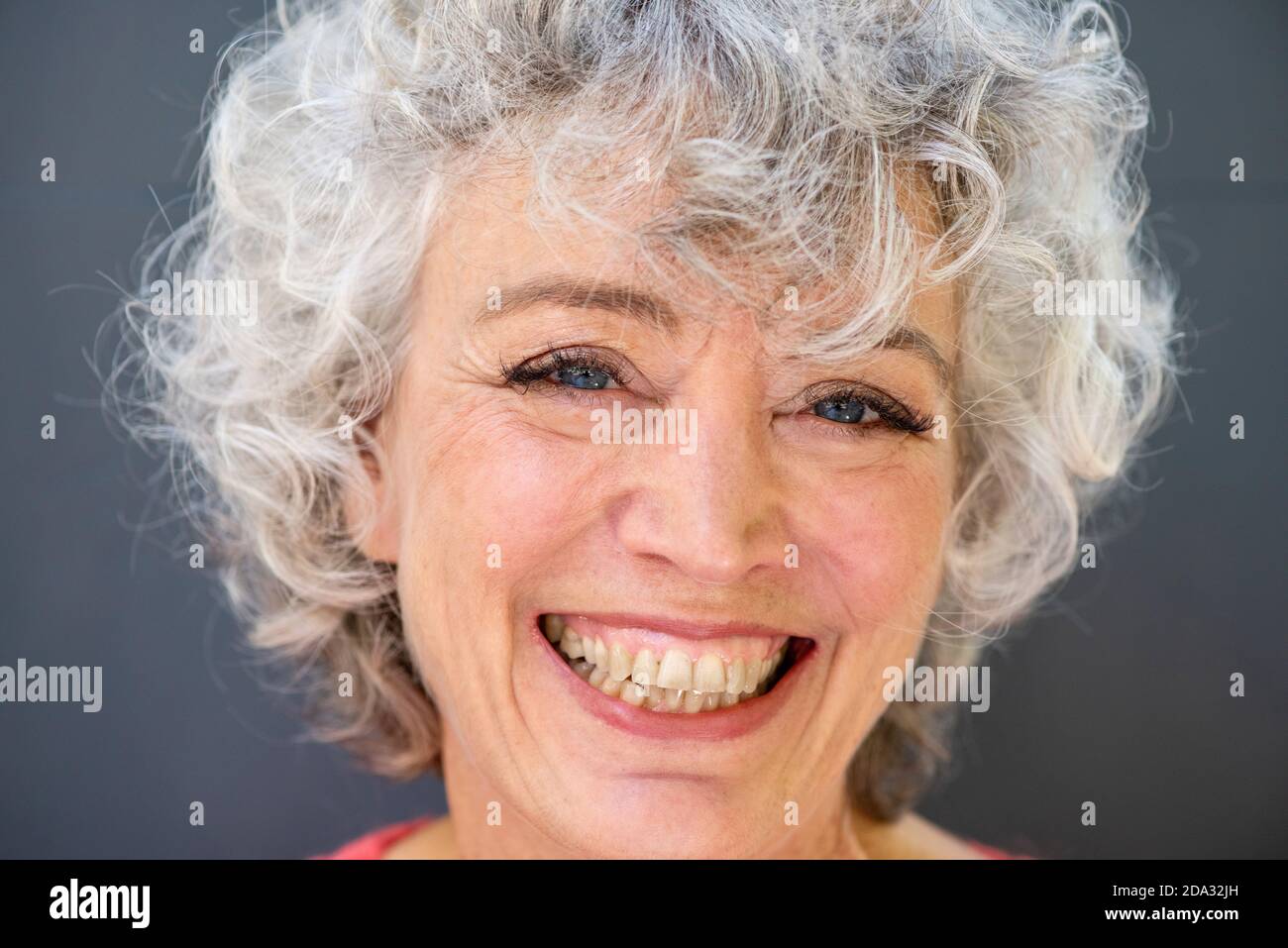 Close up portrait happy older woman smiling against gray background Stock Photo - Alamy