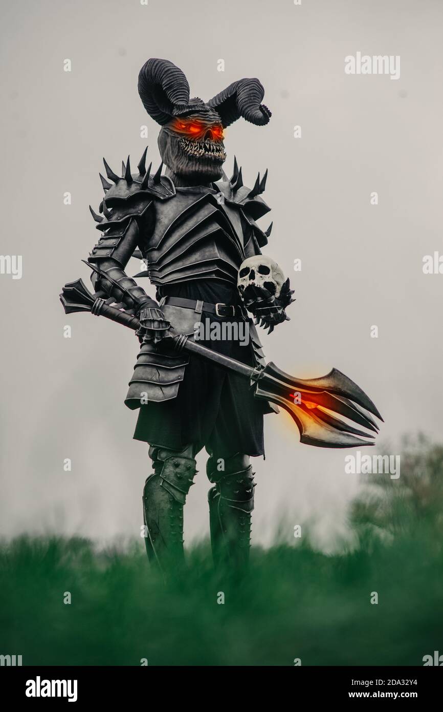 Mutant warrior stands with glowing eyes and holds mace and a human ...