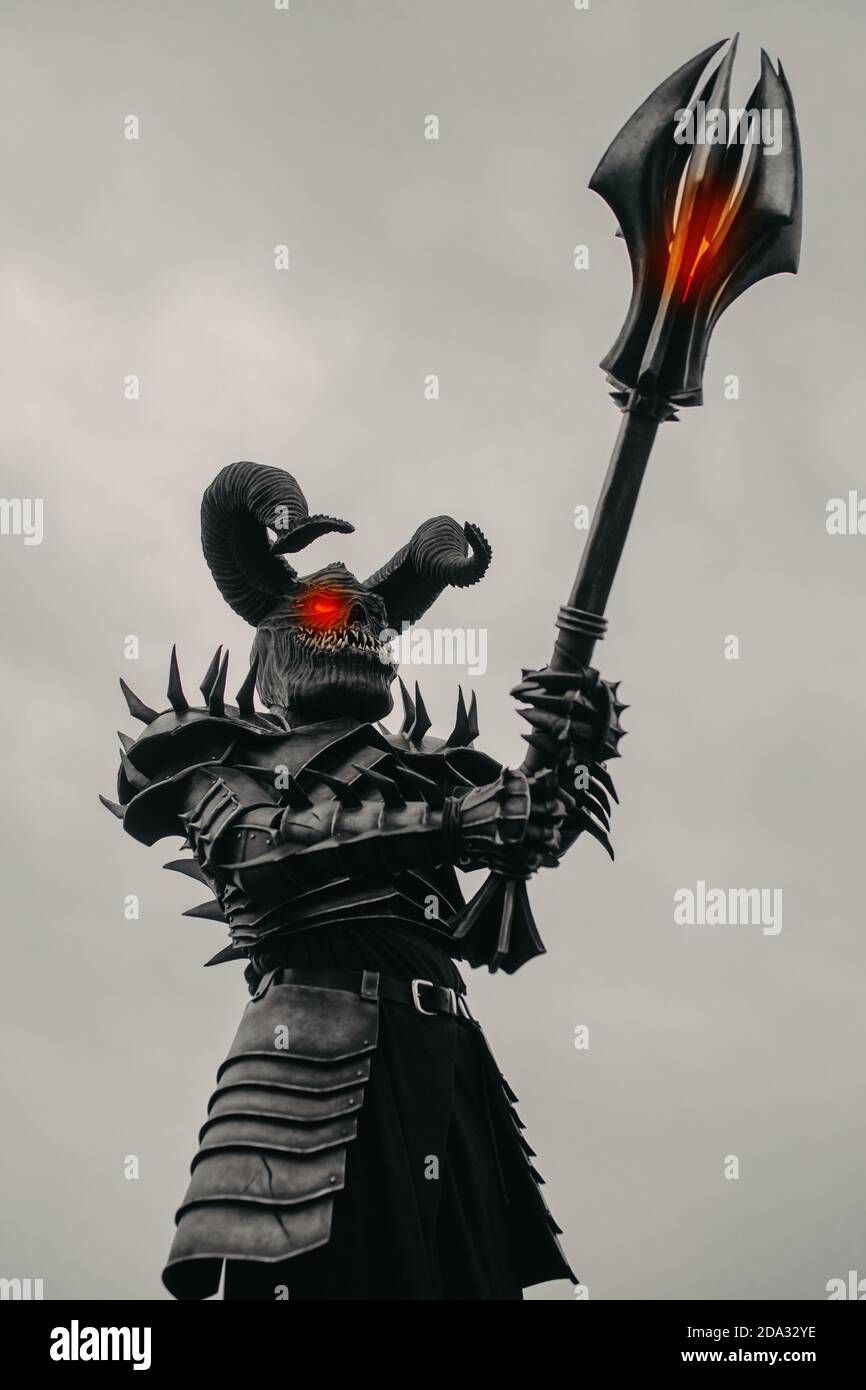 Mutant warrior stands with glowing eyes and holds mace in his hands ...