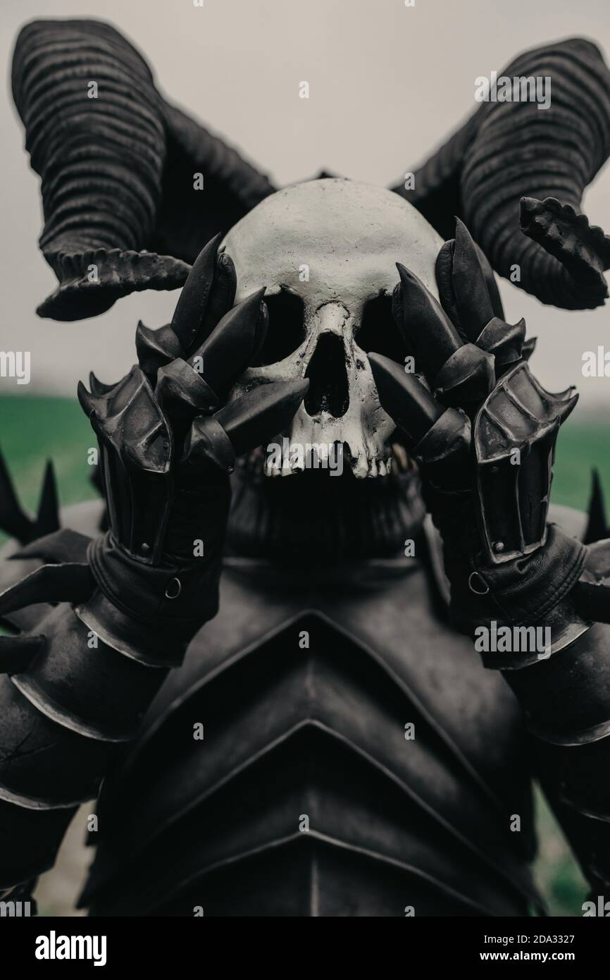 Mutant warrior holds mask in image of human skull in his hands Stock ...