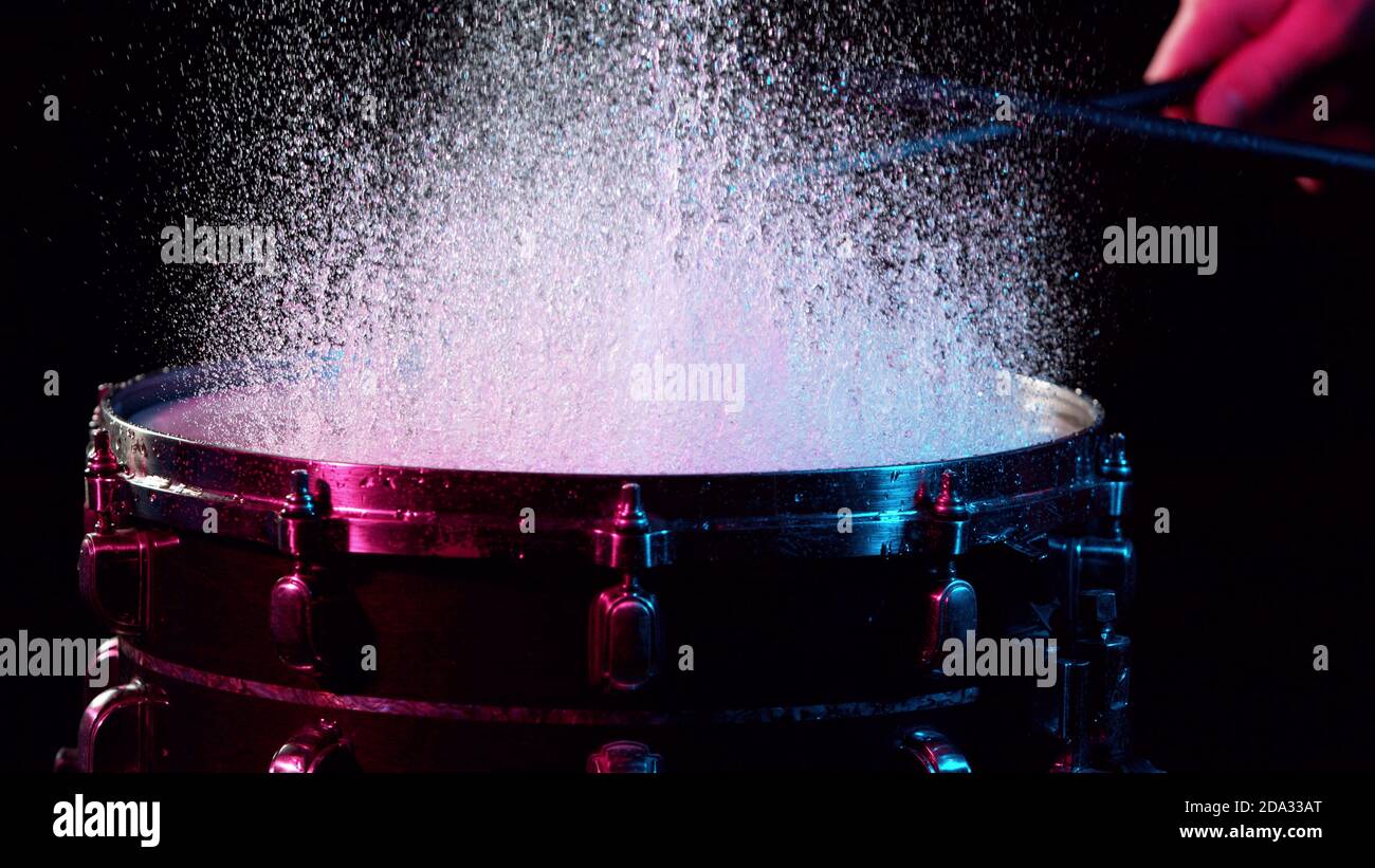 Freeze motion of drummer hitting drum with water splashes, isolated on ...