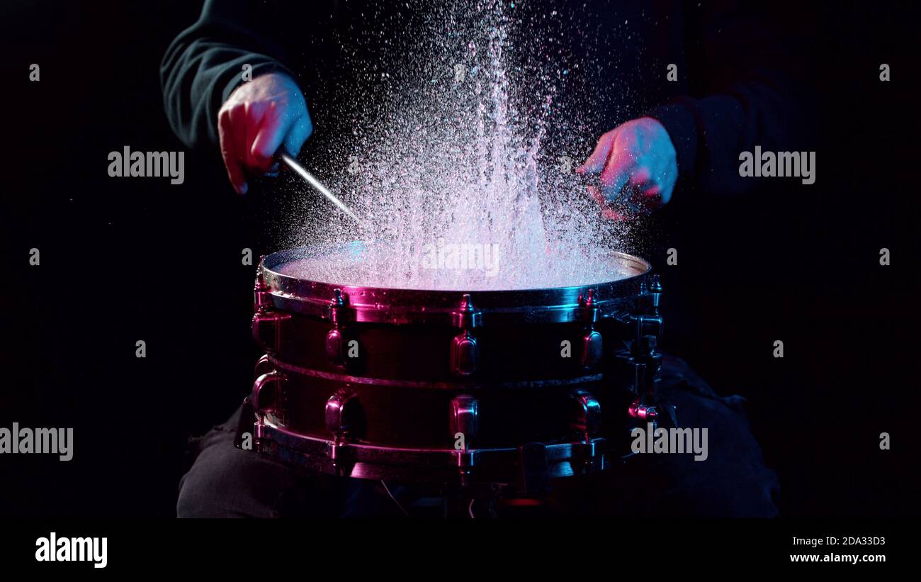 Freeze motion of drummer hitting drum with water splashes, isolated on ...