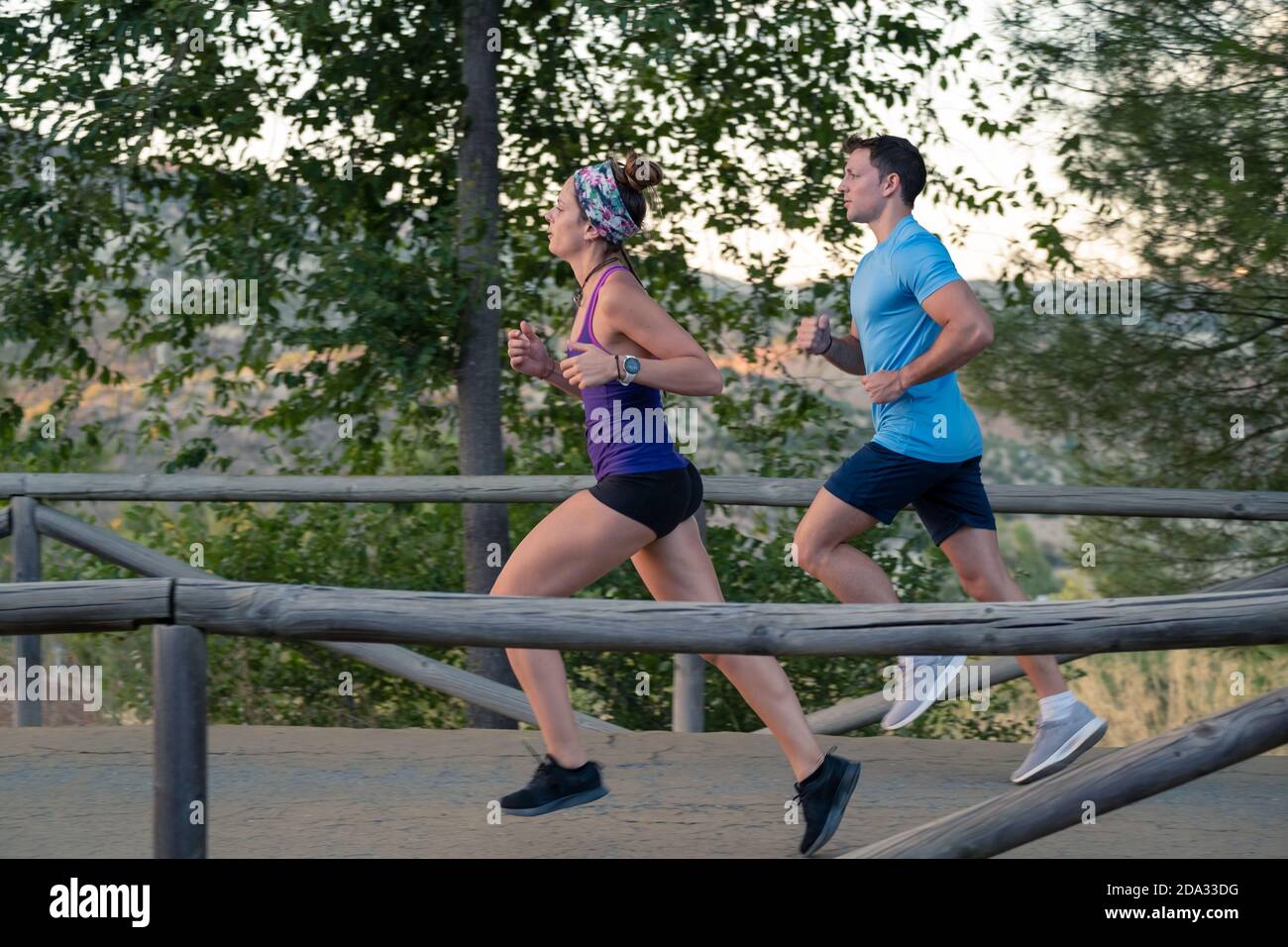Young couple running in park with trees background Stock Photo - Alamy