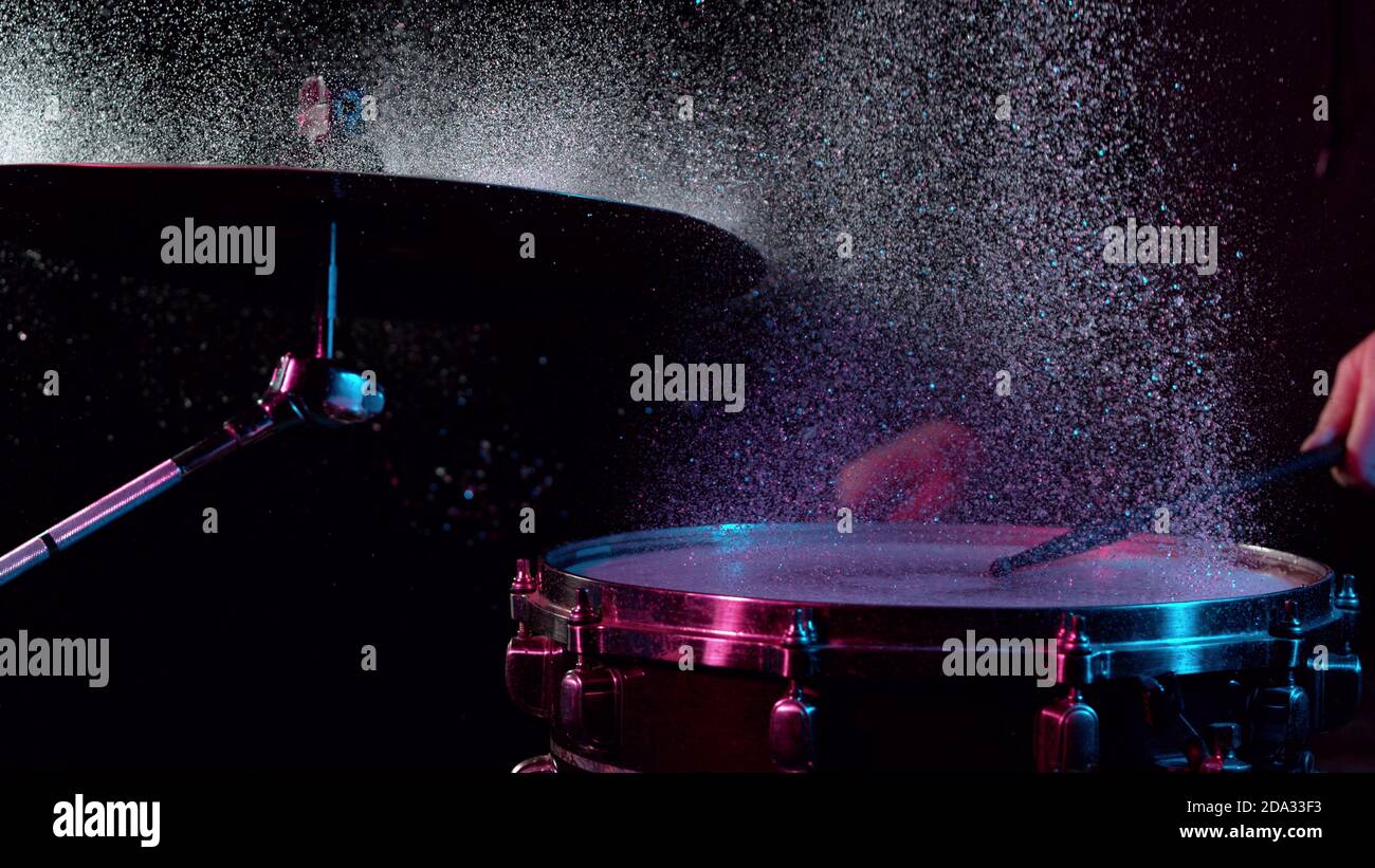 Freeze motion of drummer hitting drums with water splashes, isolated on ...