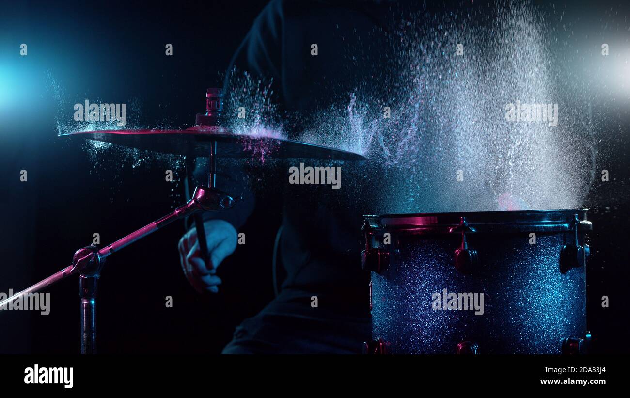 Freeze motion of drummer hitting drums with water splashes, isolated on ...