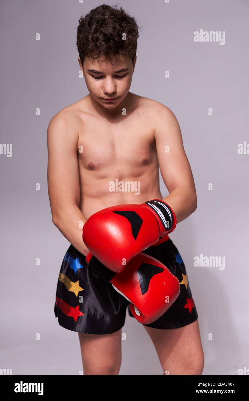 Young kickboxing fighter in red gloves with various strikes posing on ...