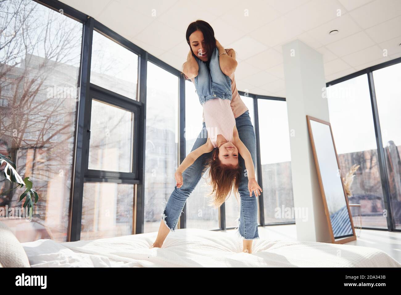 Young mother with her daughter spending weekend together on bed Stock ...
