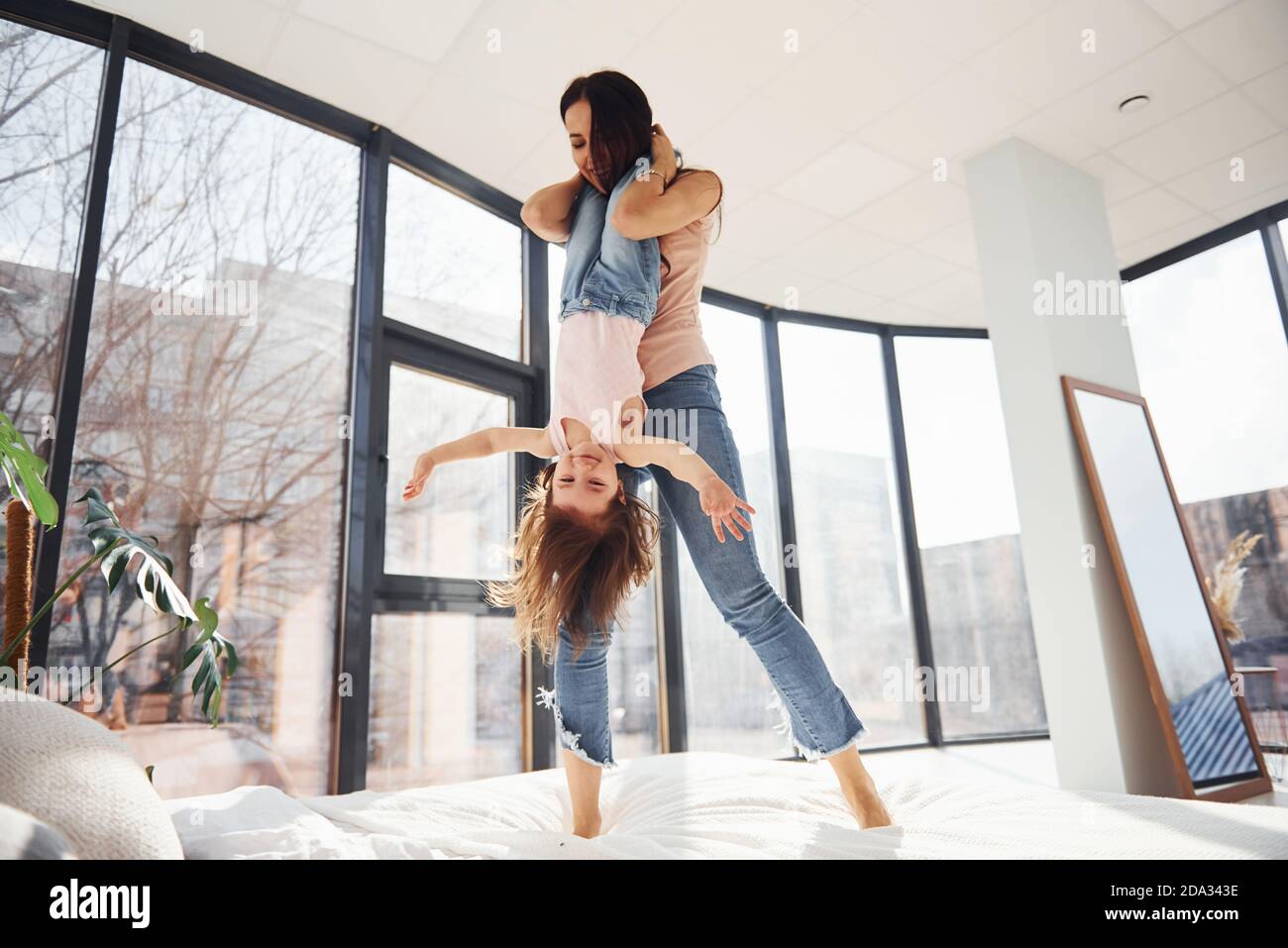 Young mother with her daughter spending weekend together on bed Stock ...