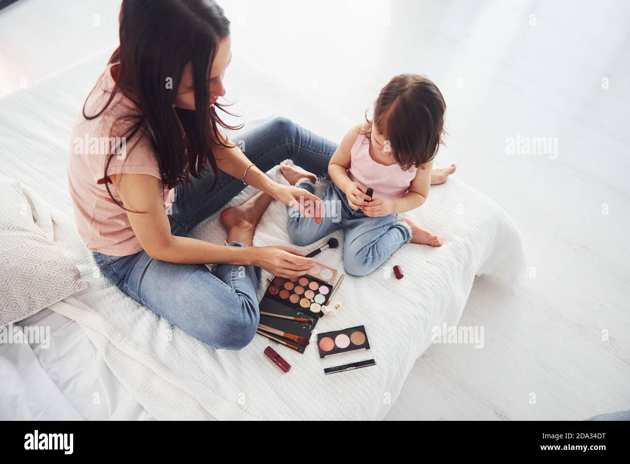 Learning how to make up. Young mother with her daughter spending ...