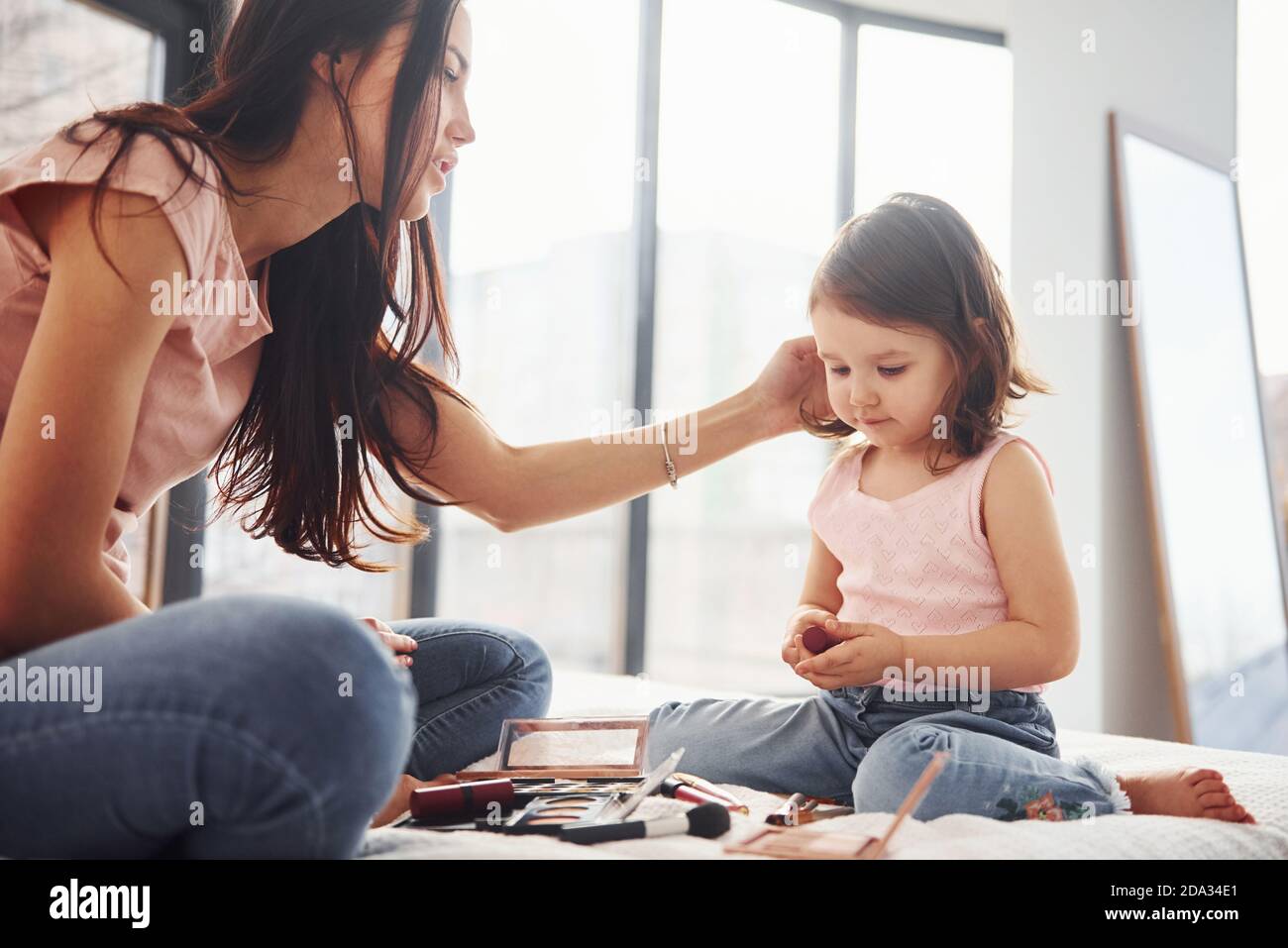 Learning how to make up. Young mother with her daughter spending ...