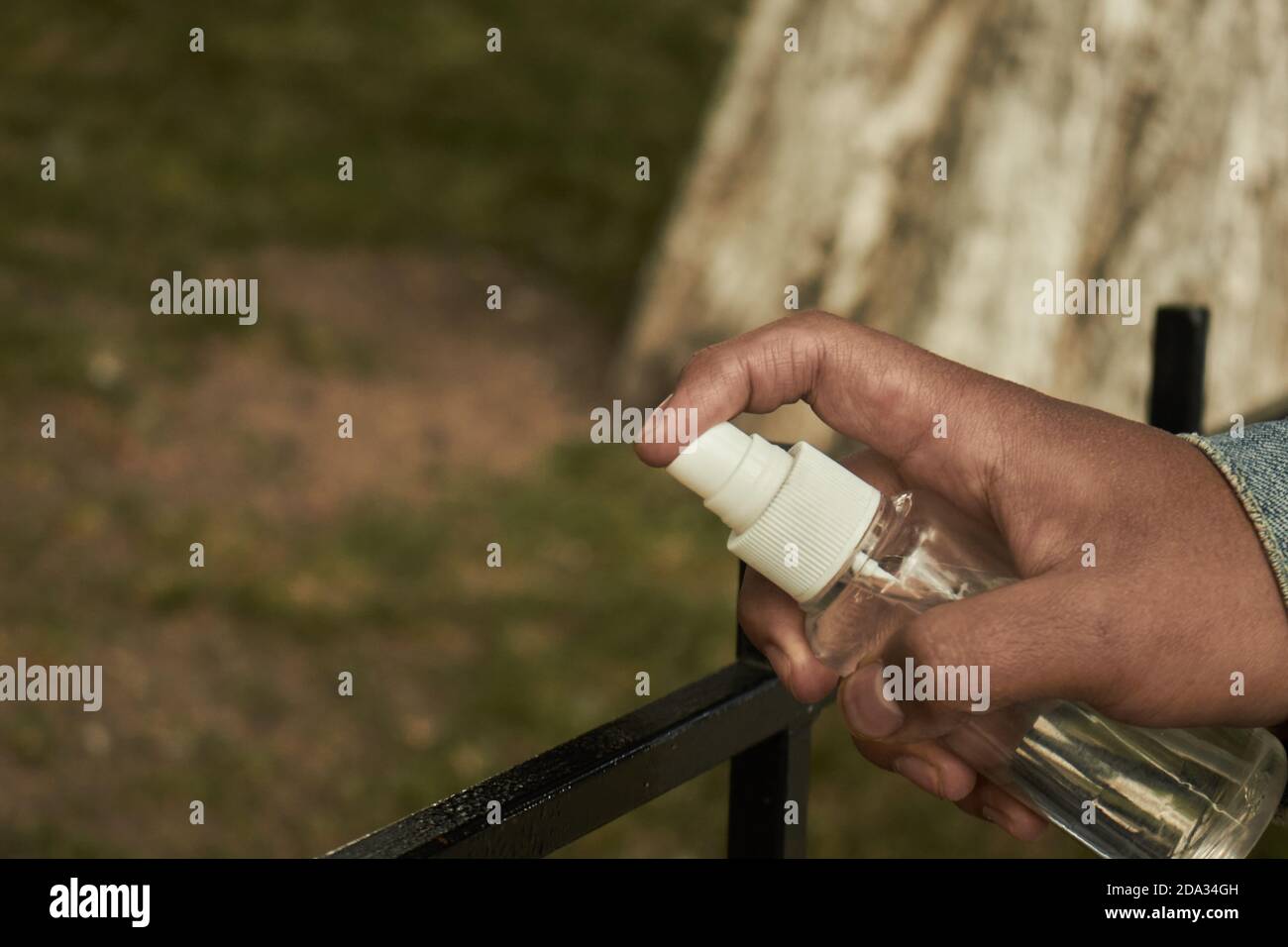Hand spraying a medicinal alcohol on a handrail Stock Photo - Alamy
