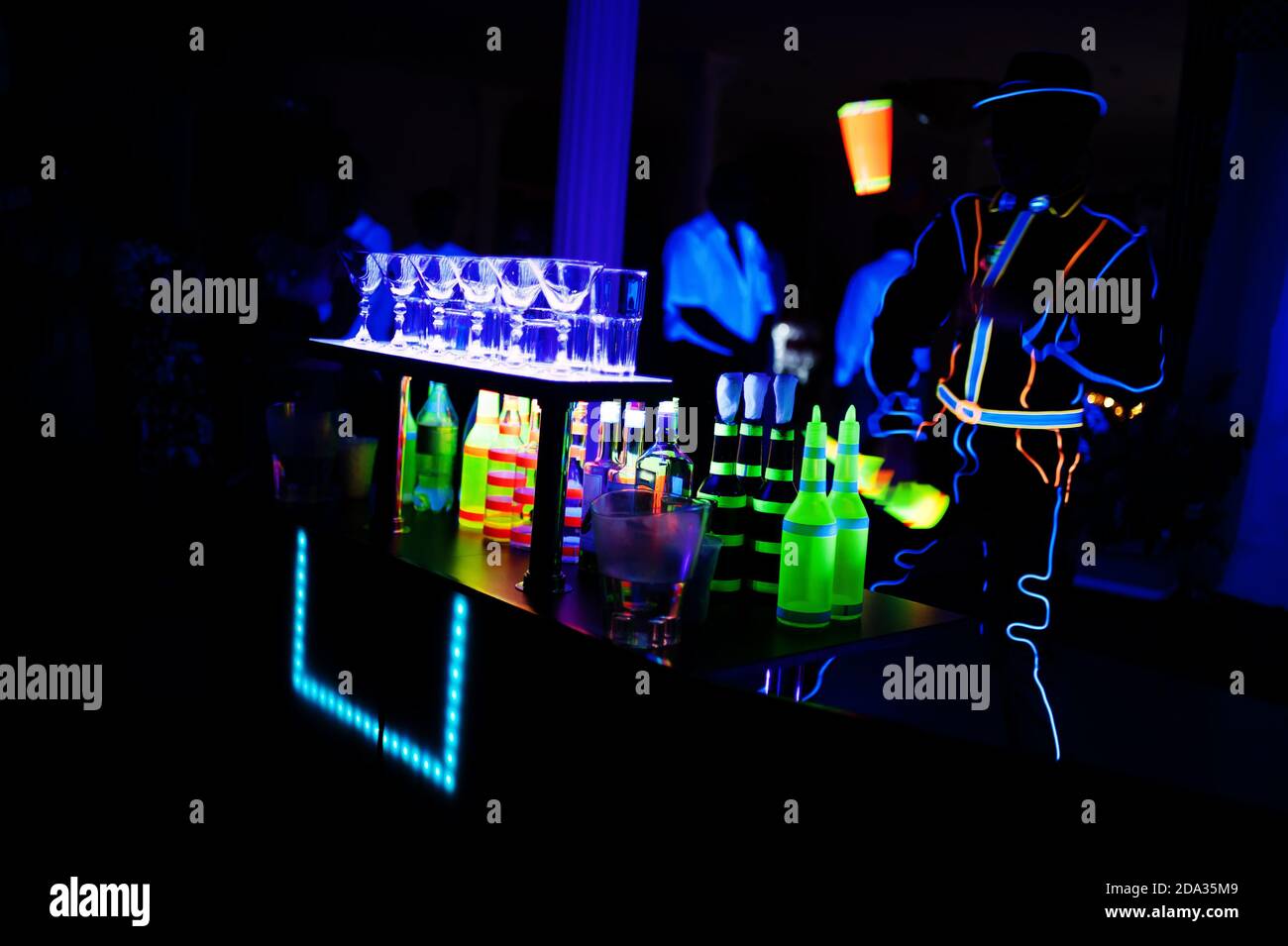Professional barman and led light show. Silhouette of modern bartender ...