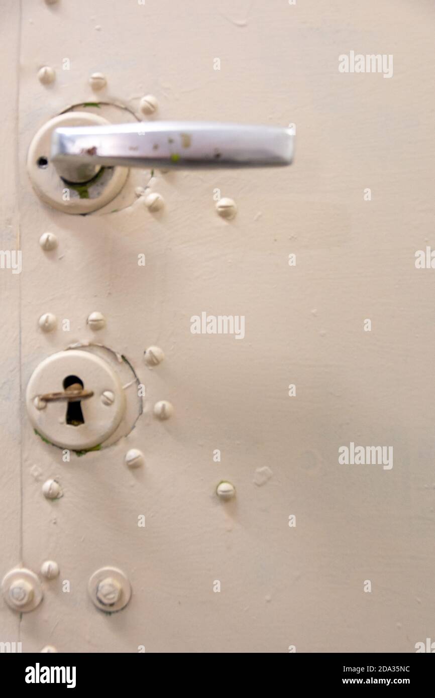 Old white metal door with lock, key and heck or door handle Stock Photo ...
