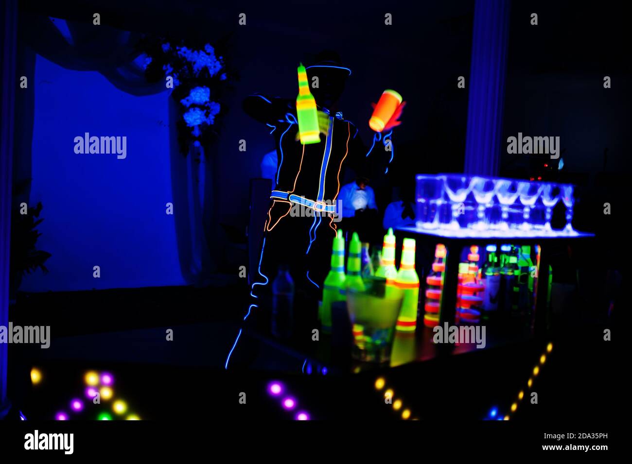 Professional barman and led light show. Silhouette of modern bartender ...