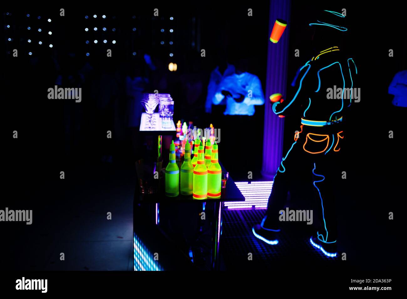 Professional barman and led light show. Silhouette of modern bartender ...