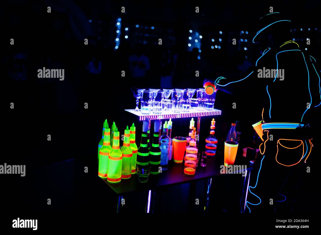 Professional barman and led light show. Silhouette of modern bartender ...