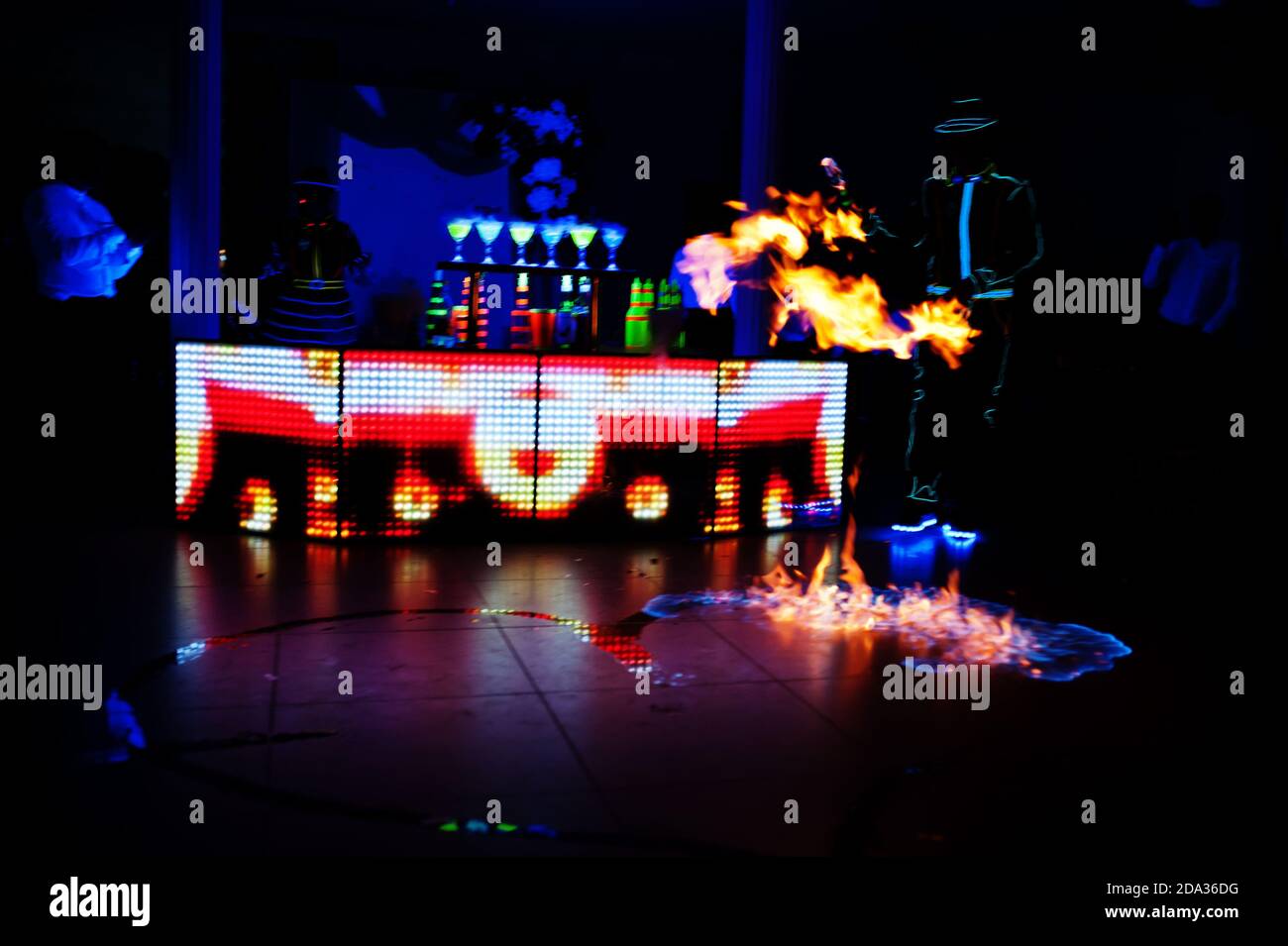 Professional barman and led light fire show. Silhouette of modern ...