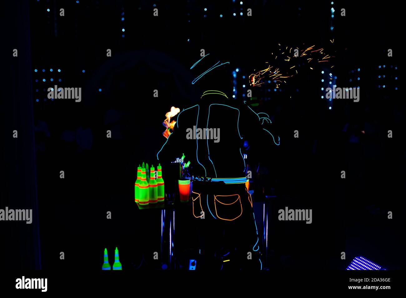 Professional barman and led light fire show. Silhouette of modern ...
