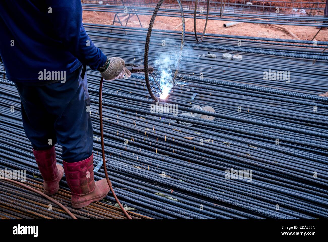 Worker welding steel rebar for reinforcement concrete in the ...