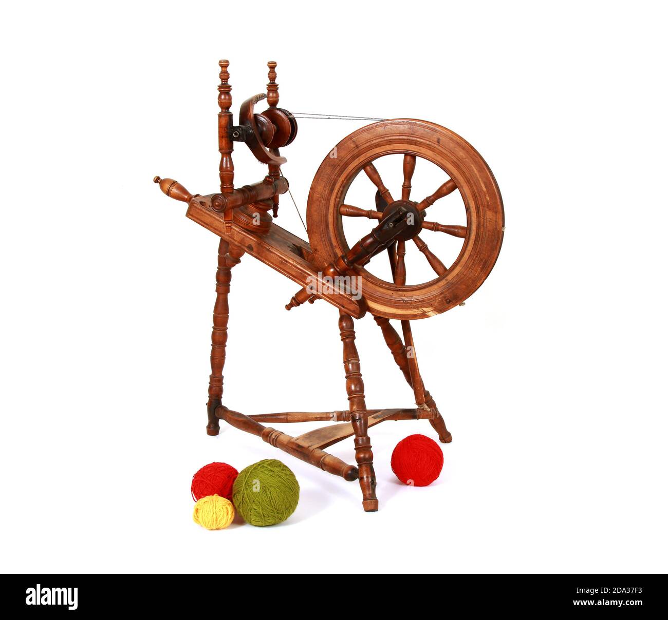 Closeup shot of an old wooden spinning wheel with balls of yarn ...