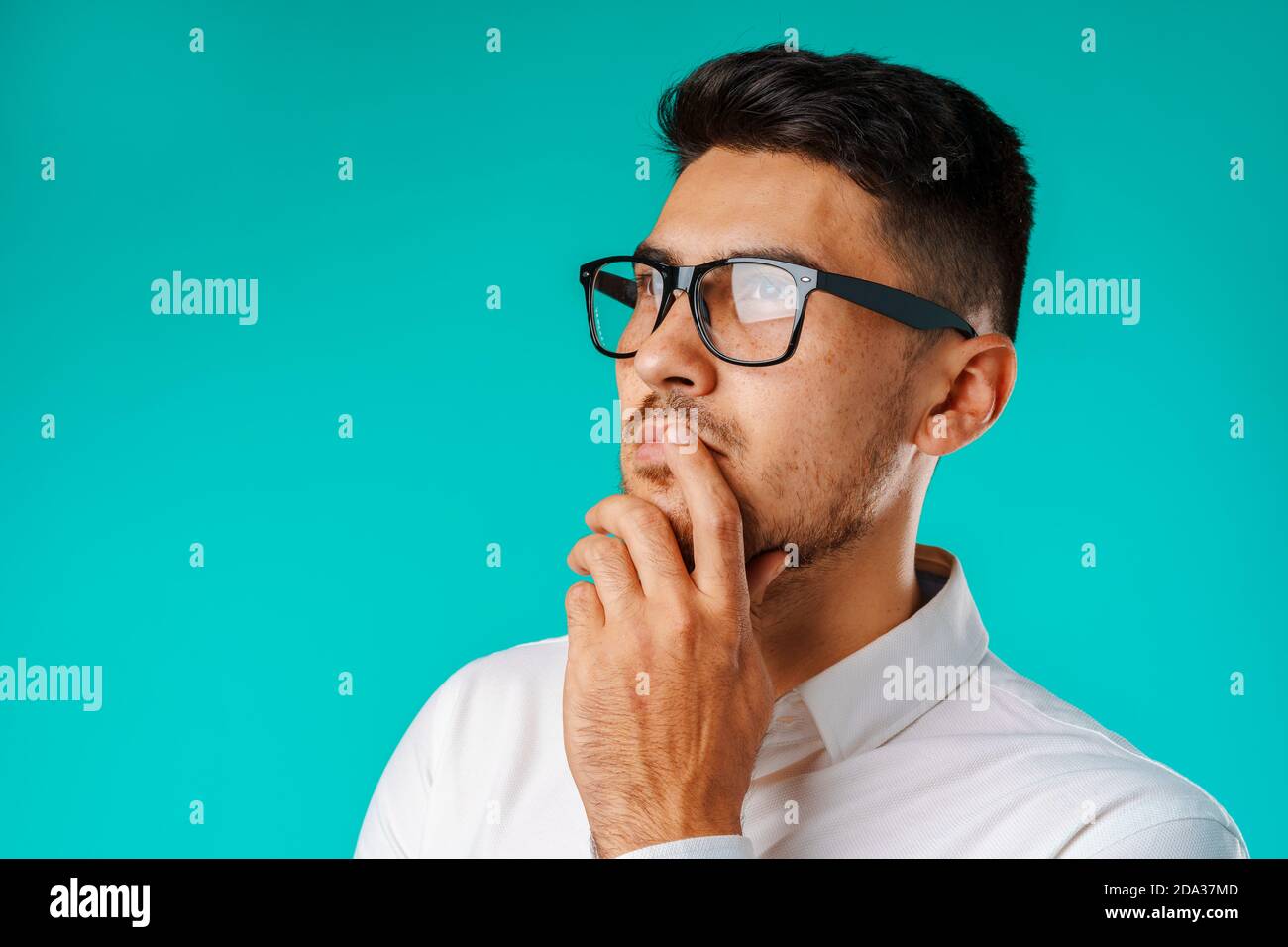 Photo of thoughtful young man touching his chin Stock Photo - Alamy