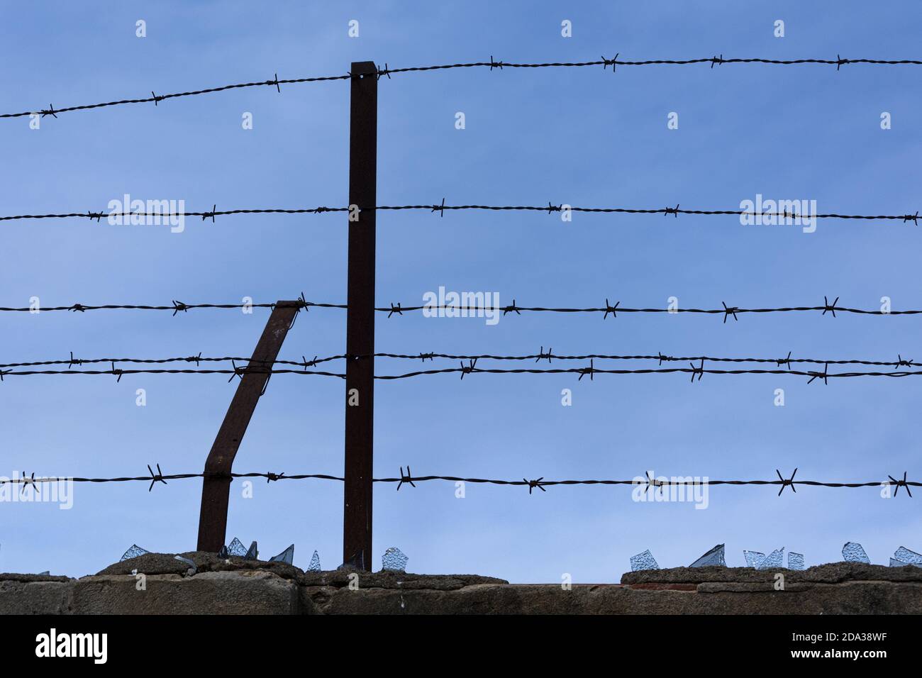 Wall with barbed wire protection Stock Photo - Alamy